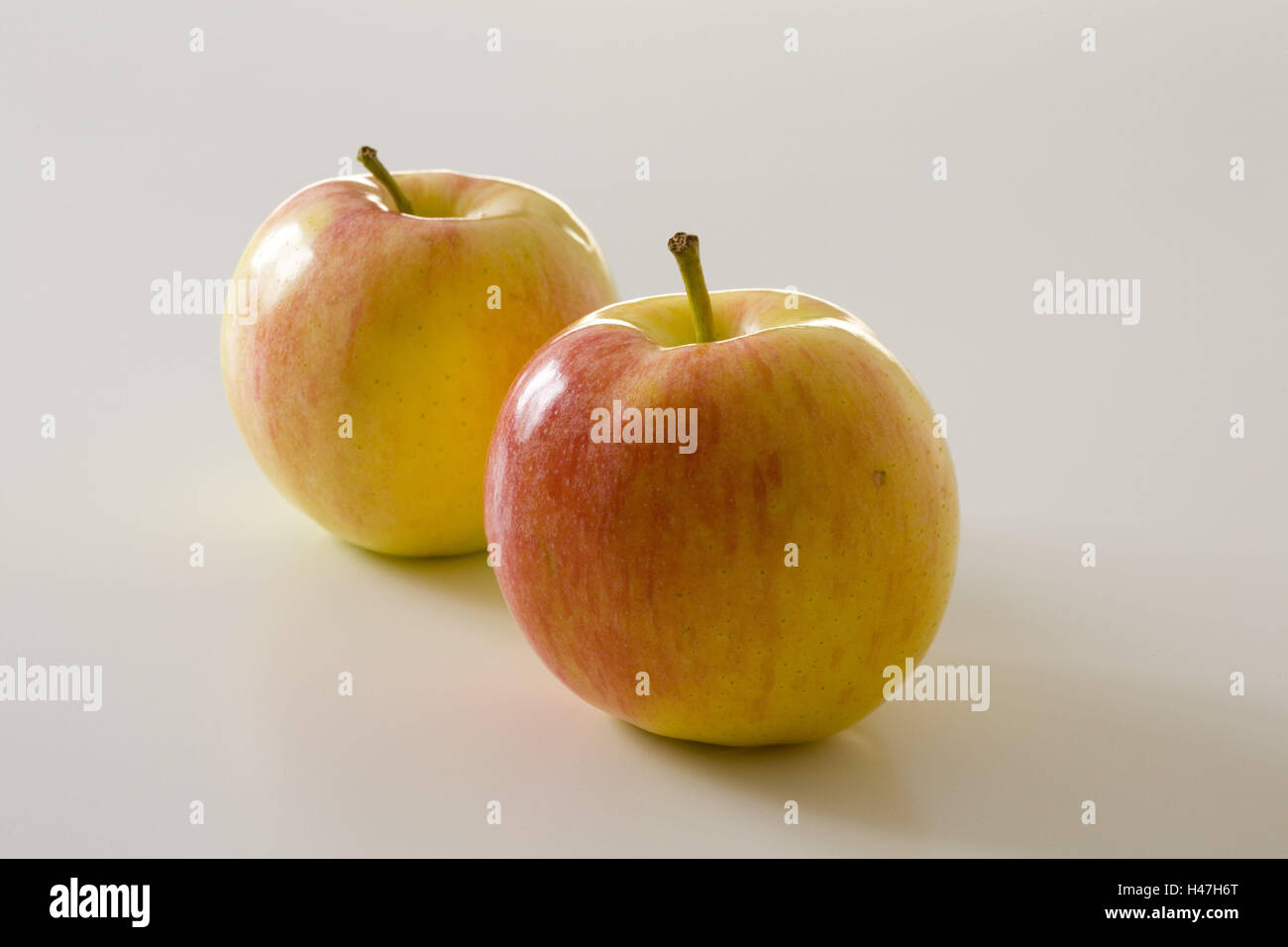 Two apples on white table Stock Photo - Alamy