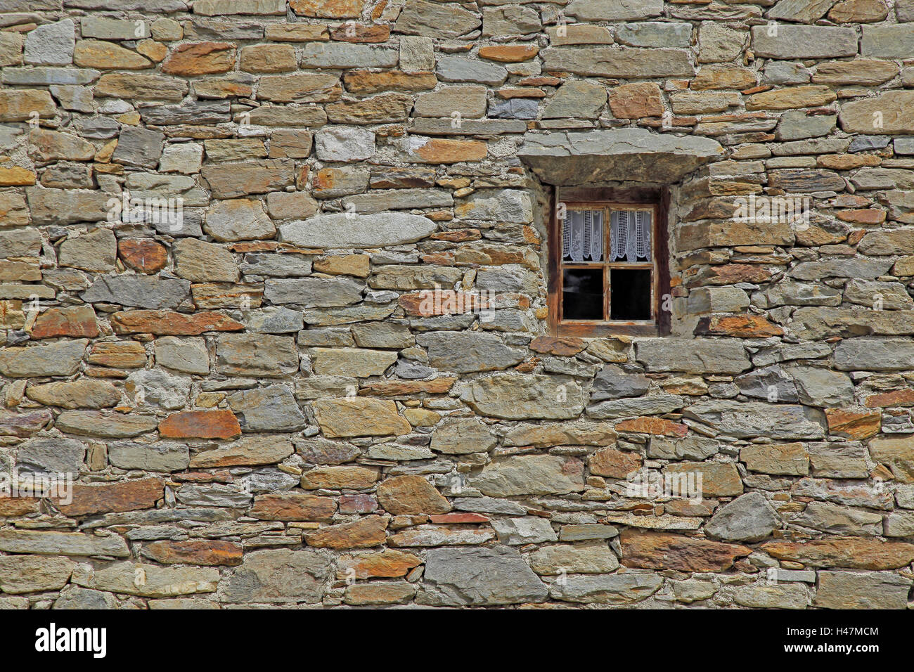 Quarrystone wall with small window Stock Photo - Alamy