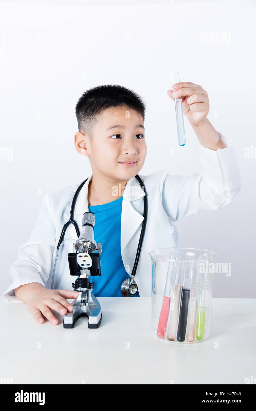 Asian Chinese boy holding test tube for research in isolated plain ...