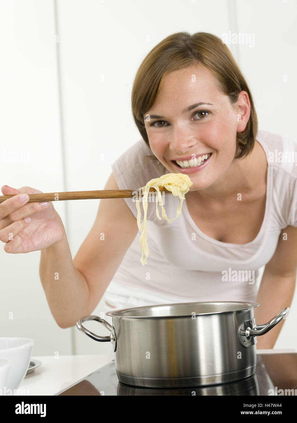 Woman, young, cooking, wooden spoons, saucepan, paste, smile Stock ...