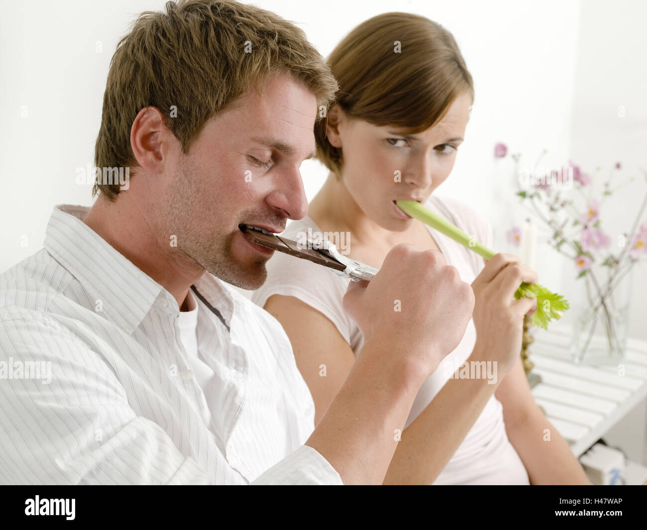 Couple, young, diet, chocolate, vegetables, envy Stock Photo - Alamy