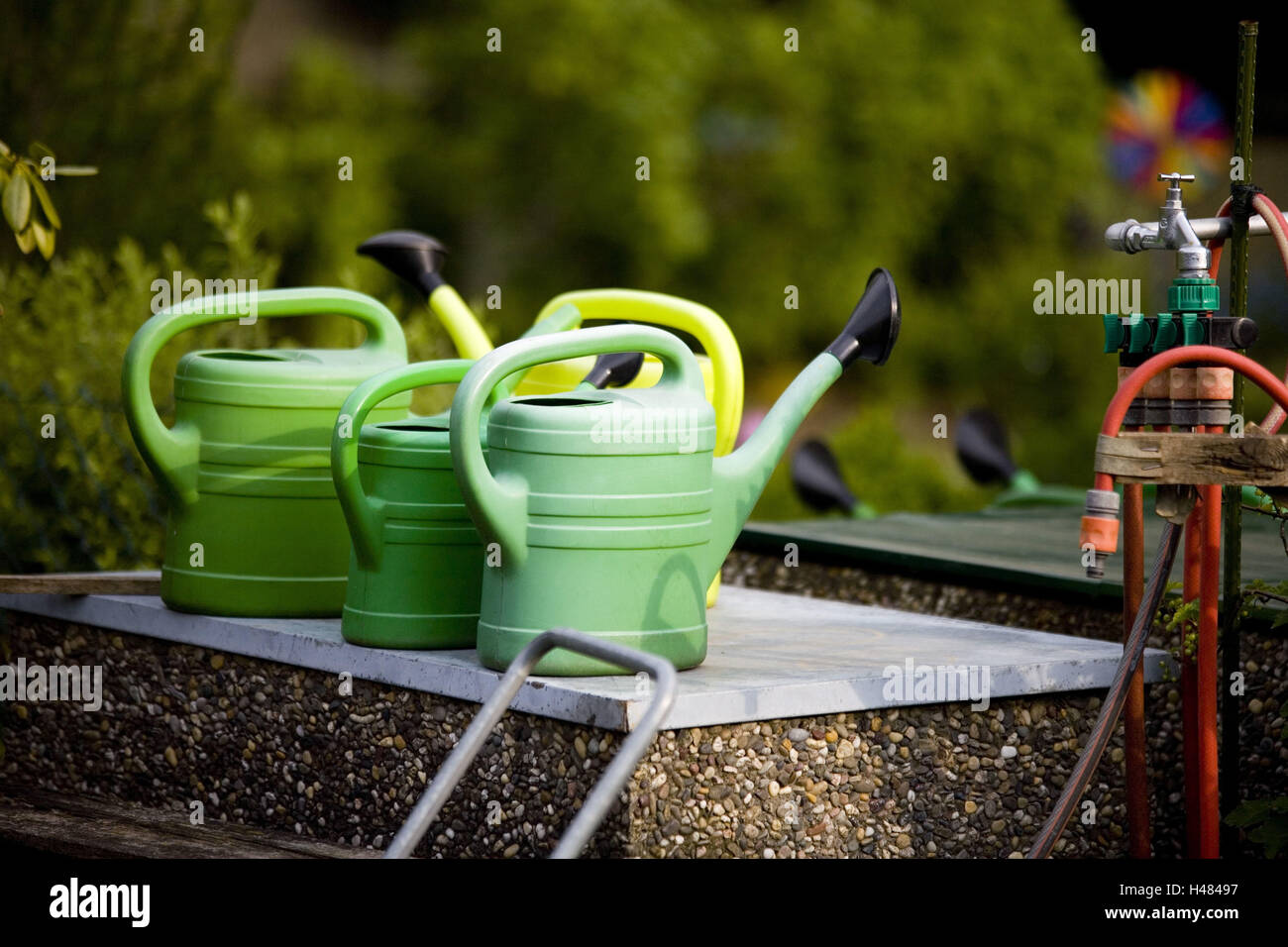 Watering cans in the garden Stock Photo - Alamy