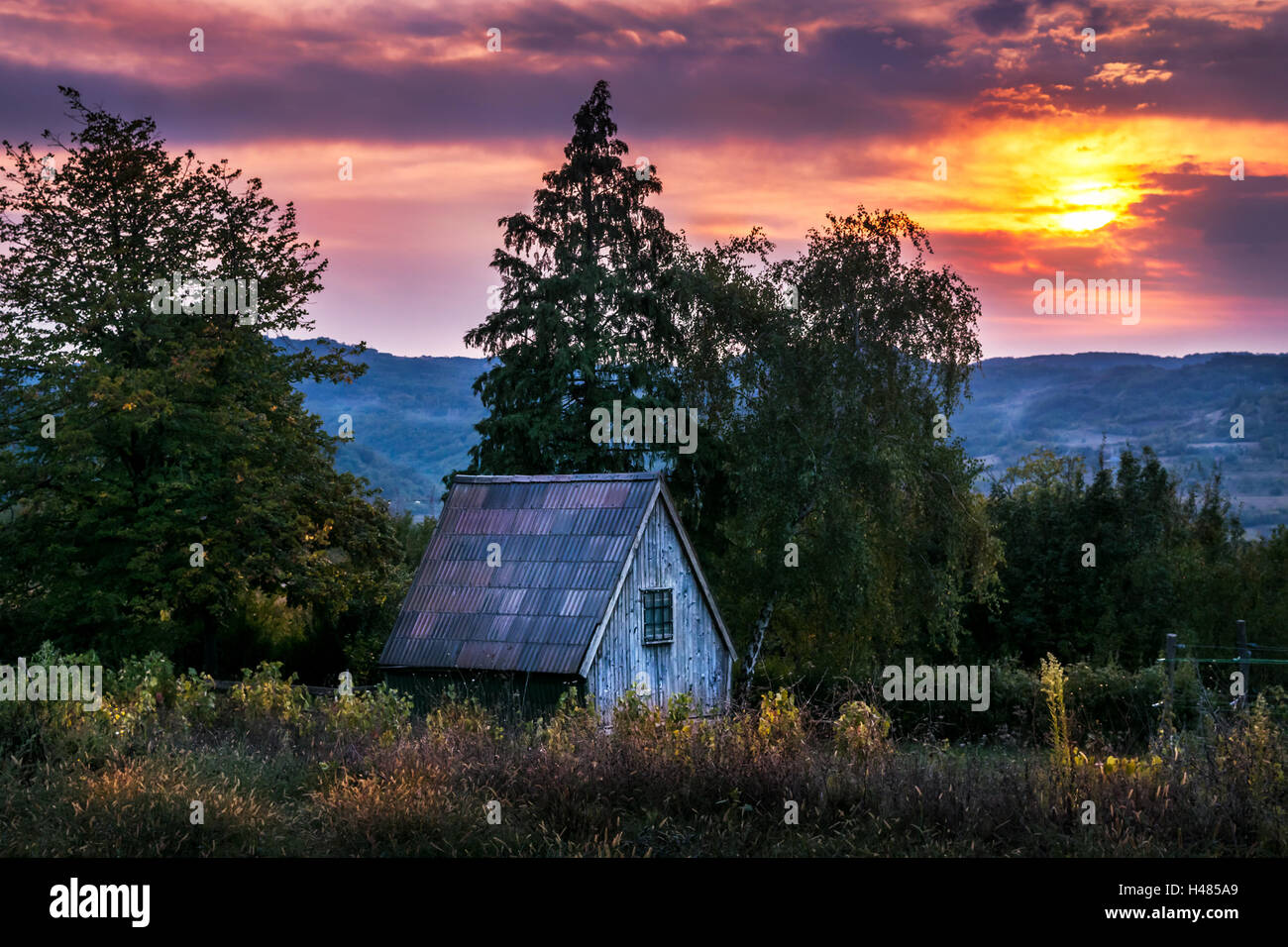 Small hillside cottage at sunset Stock Photo - Alamy