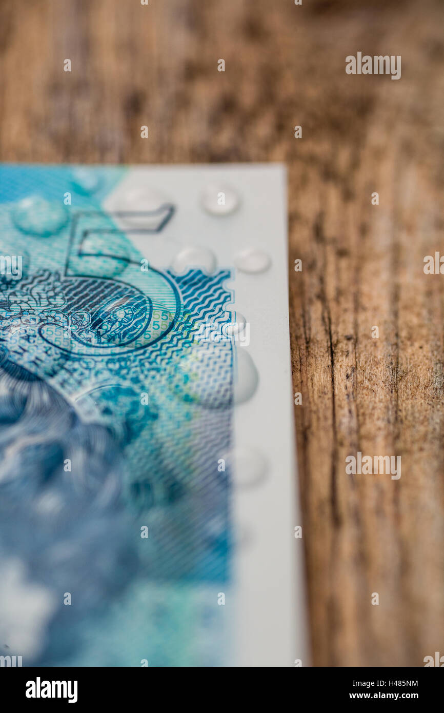 New United Kingdom five pound note. Water droplets showing its plastic ...