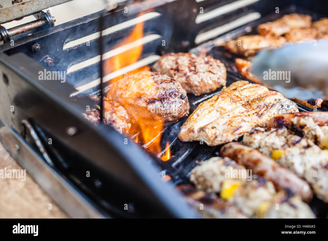 Various meats and fish grilling on a gas barbeque in the back garden ...
