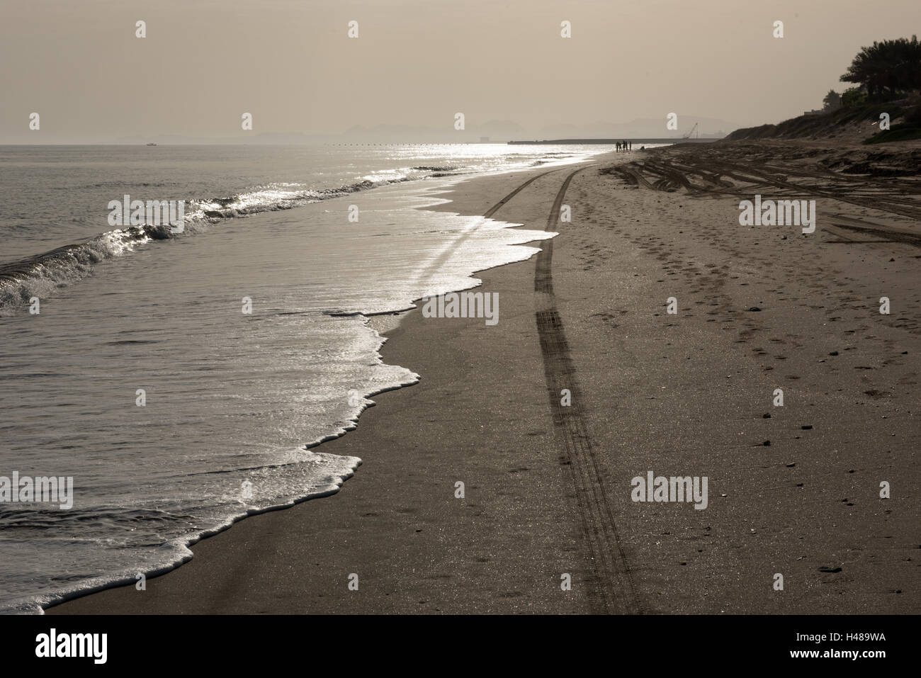 Wave washing over tyre marks on the beach at sunrise Stock Photo - Alamy