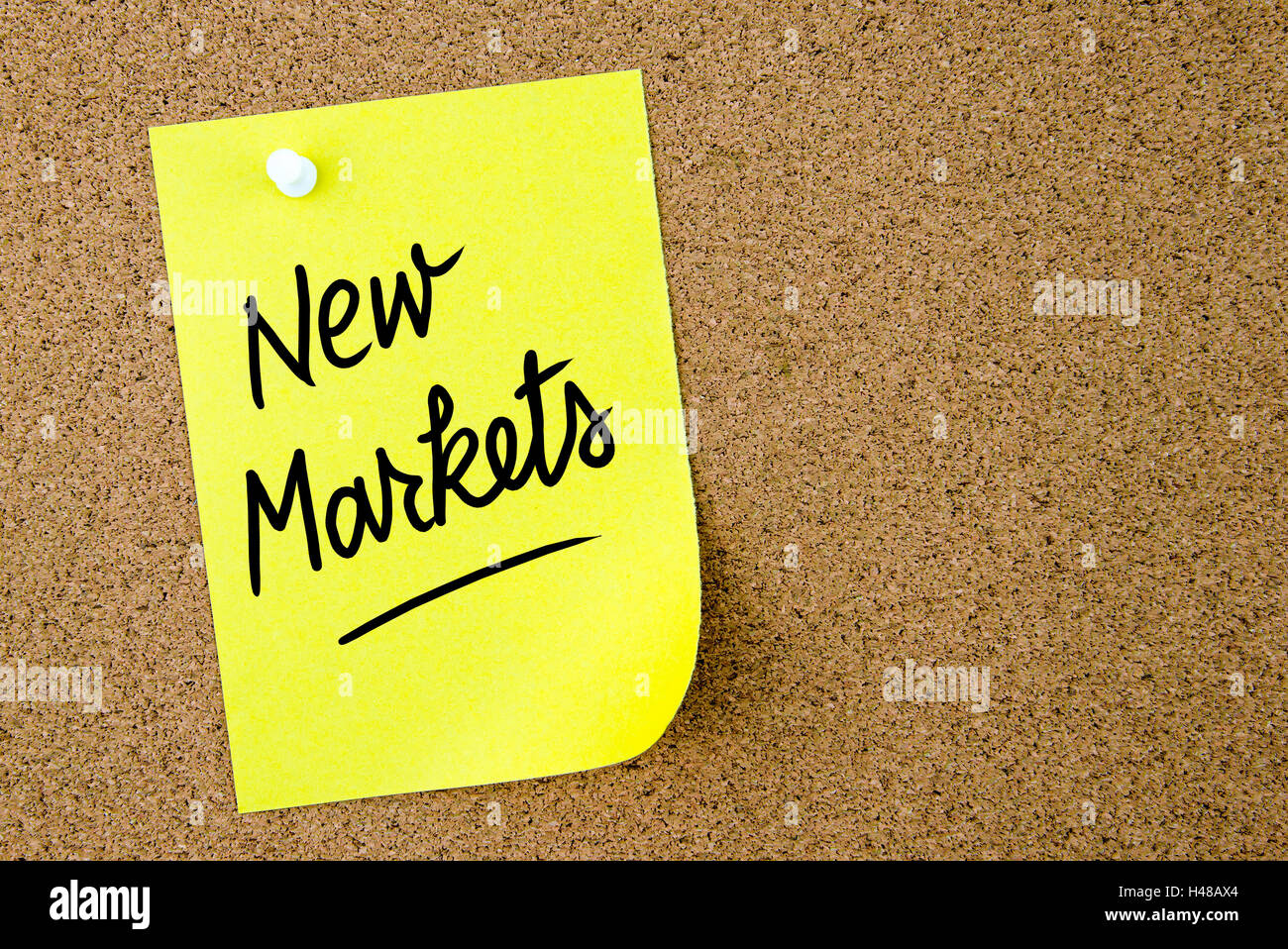 New Markets text written on yellow paper note pinned on cork board with ...