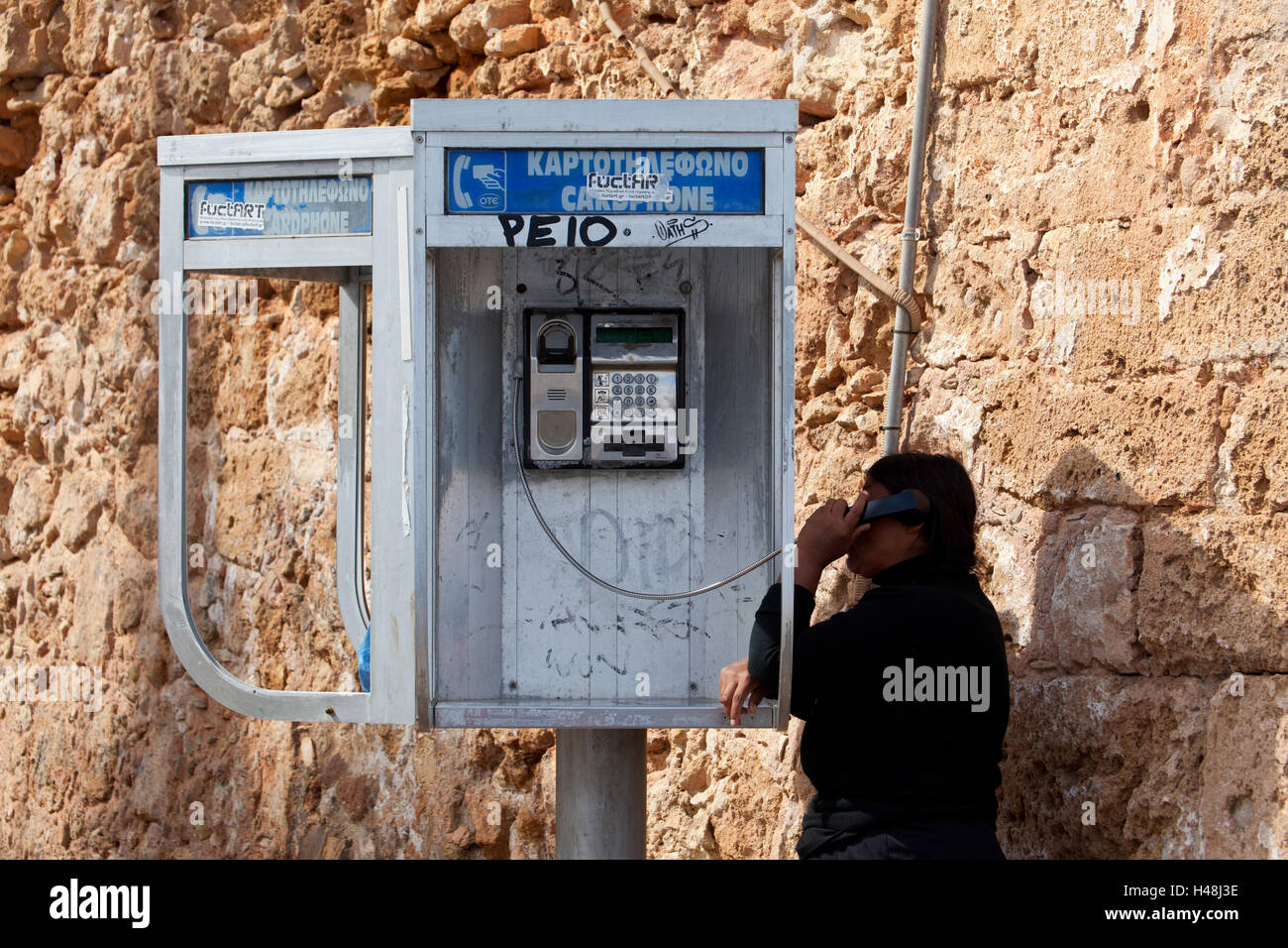 Greece, Crete, Canea, Venetian harbour, telephone box, woman Stock ...