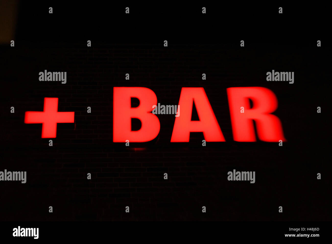 Neon lights '+BAR' in the facade of a hotel, selective focus, harbour ...