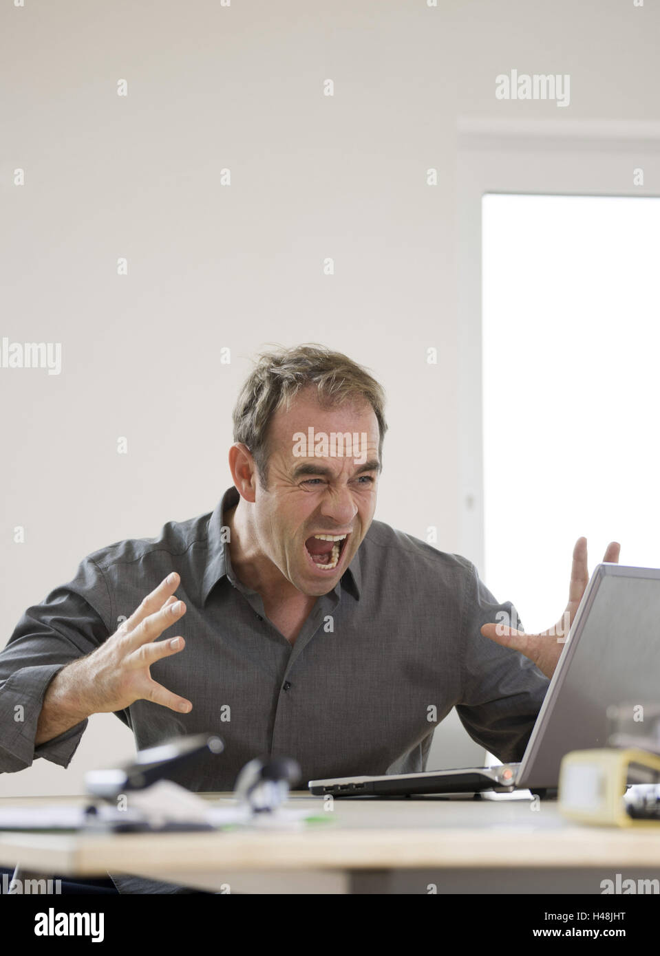 Man is screaming in front of his is laptop Stock Photo - Alamy