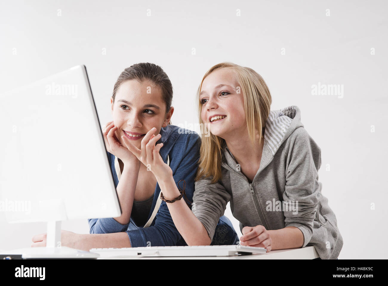 Teenage girls, two, computer, smile, studio Stock Photo - Alamy