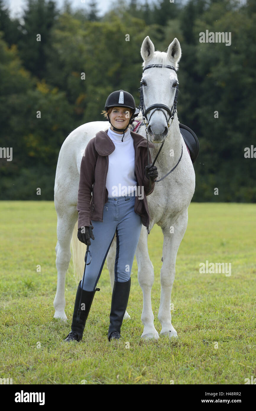 Teenage girl, horse, Bavarian warm blood, meadow, stand, head-on, view ...