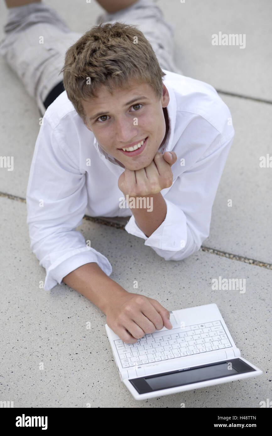 Teenager, boy, notebook computer, floor, lying, view camera, detail ...
