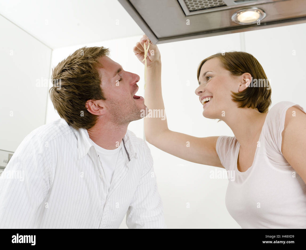 Couple, young, cooking, paste, feed, laugh Stock Photo - Alamy