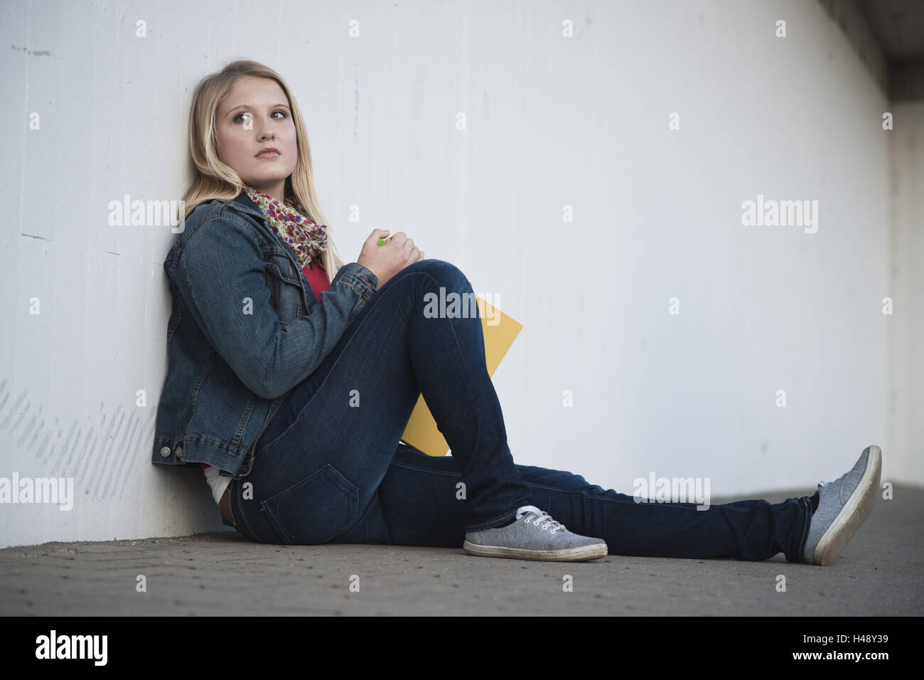 Young sad woman sitting on the floor Stock Photo - Alamy