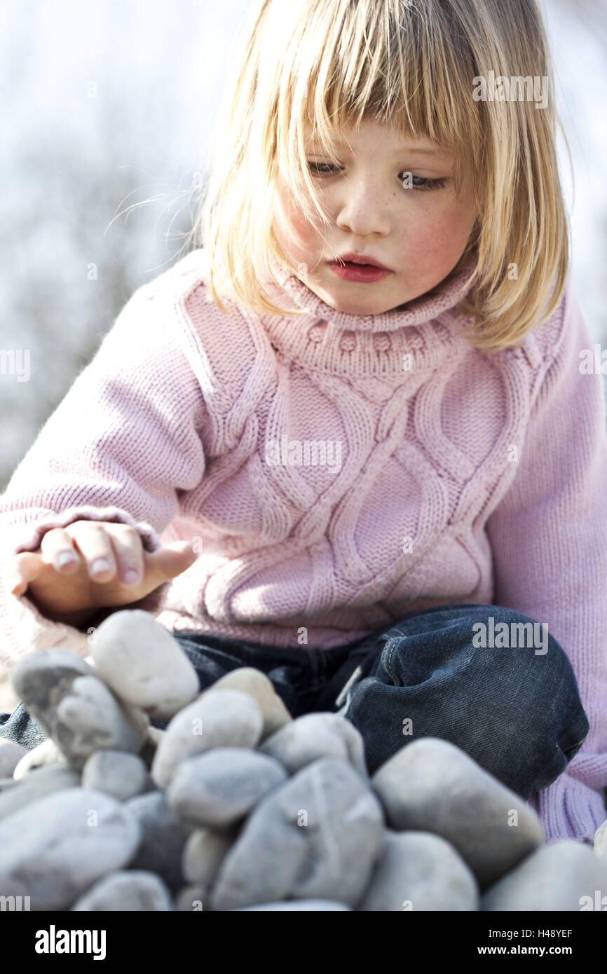 Girl playing with stones Stock Photo - Alamy
