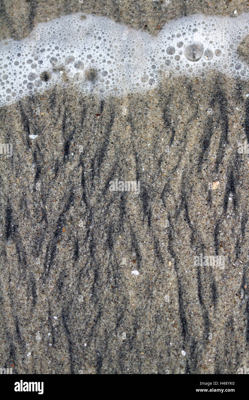 close up of a beach sand with different layers of white and black sand ...