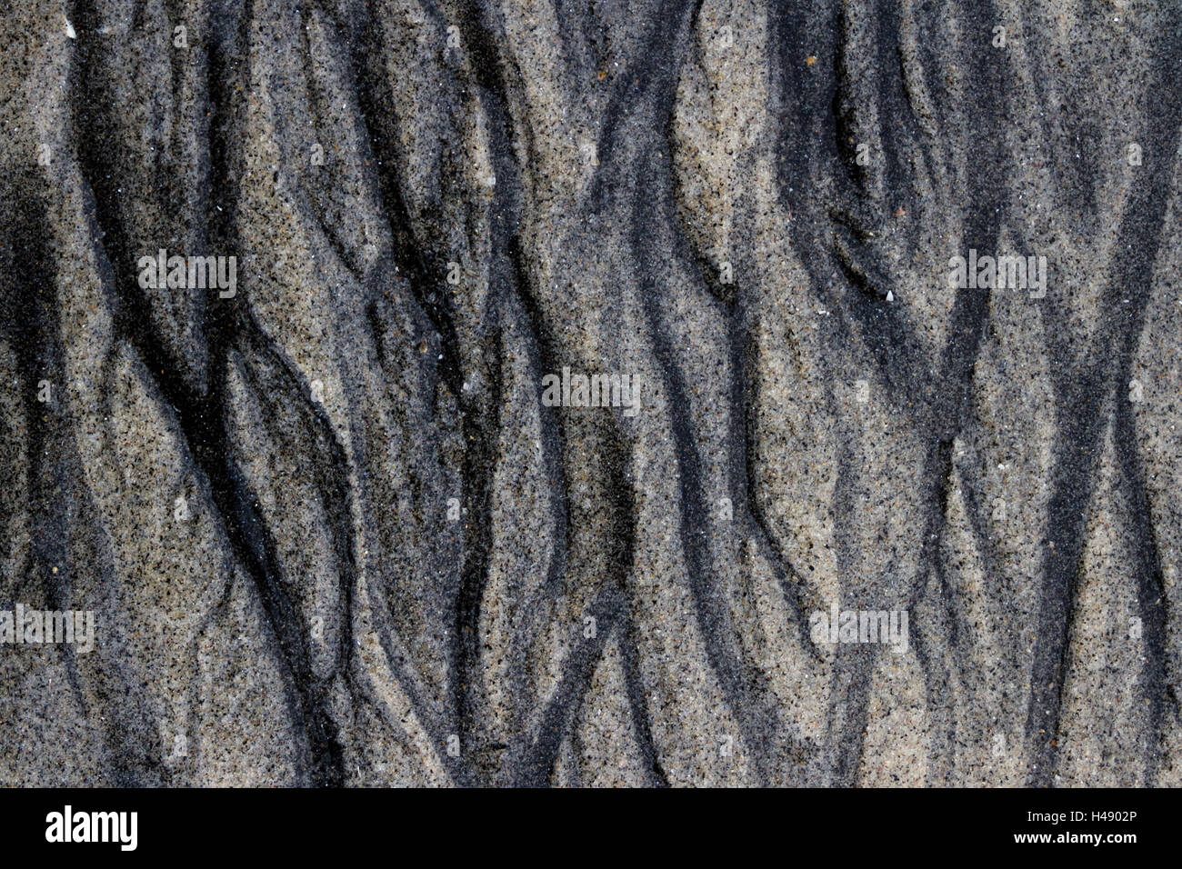 close up of a beach sand with different layers of white and black sand ...
