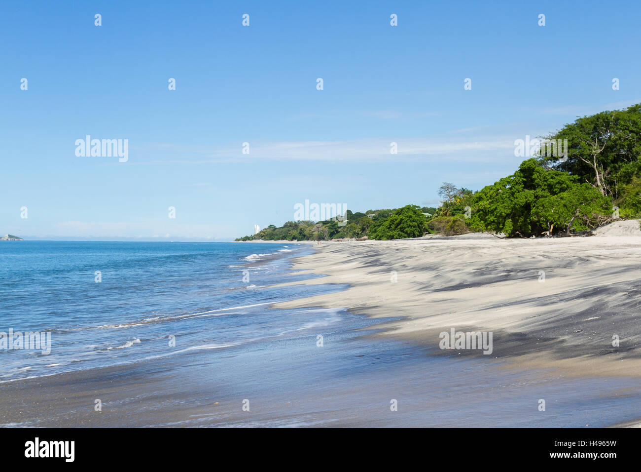 relaxing beach with blue water and layers of white and black sand in ...
