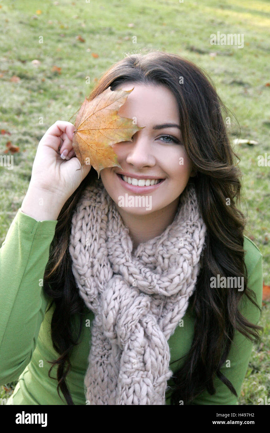 Woman, smiling, leaf in front of eye, portrait Stock Photo - Alamy