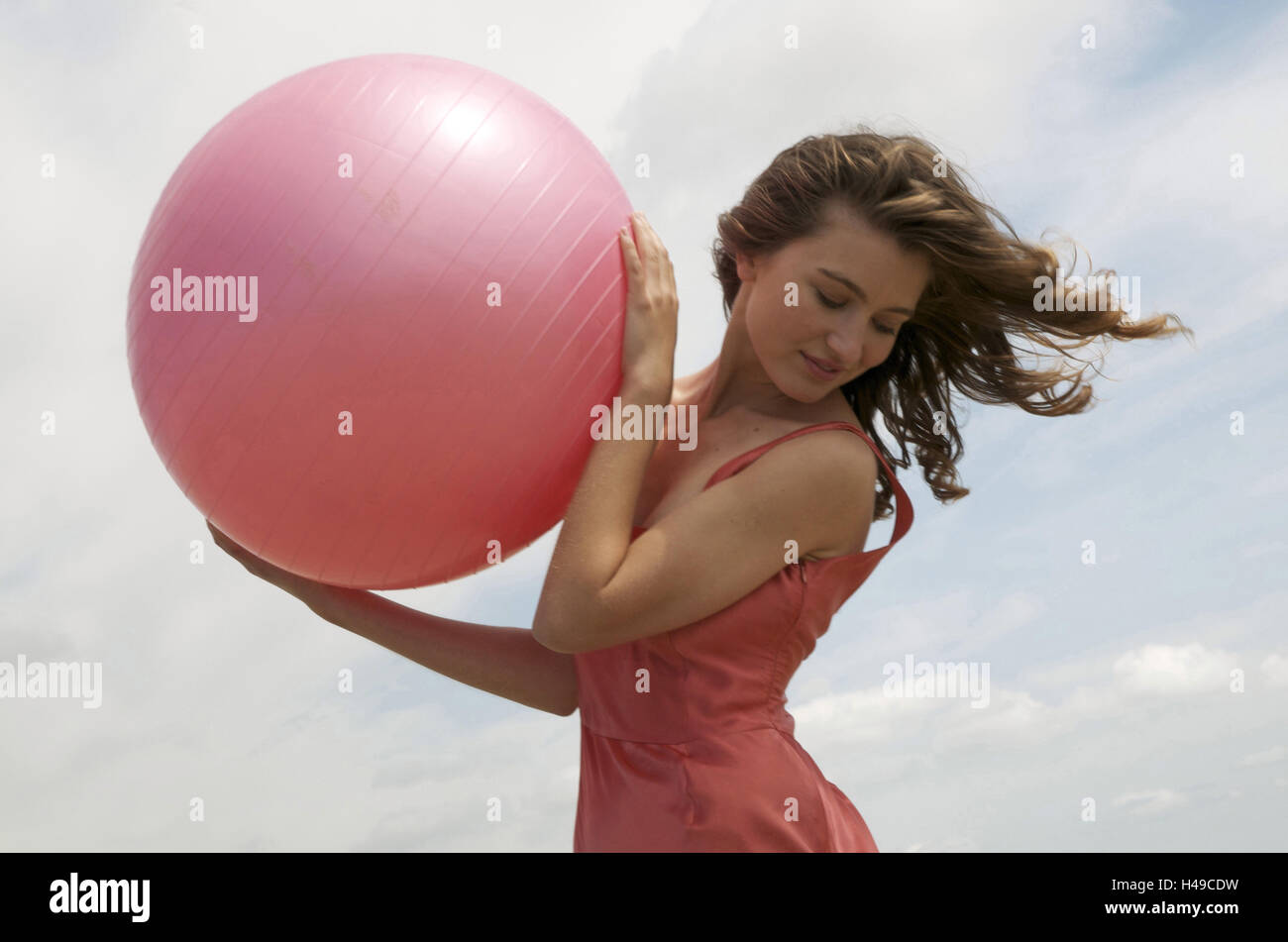 young woman holds red ball, outside, half portrait, side view Stock ...