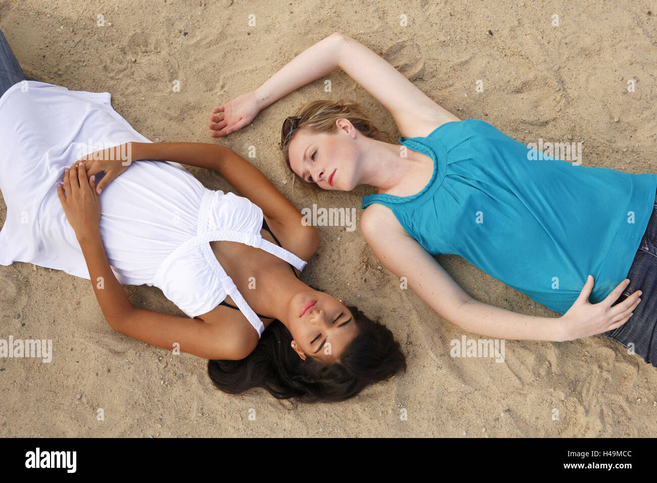 Two young women lying in sand hi-res stock photography and images - Alamy