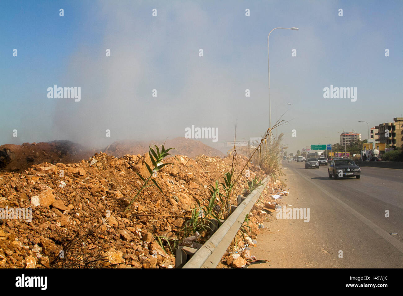 Beirut, Lebanon. 14th Oct, 2016. Cars drive past smoke billowing from ...