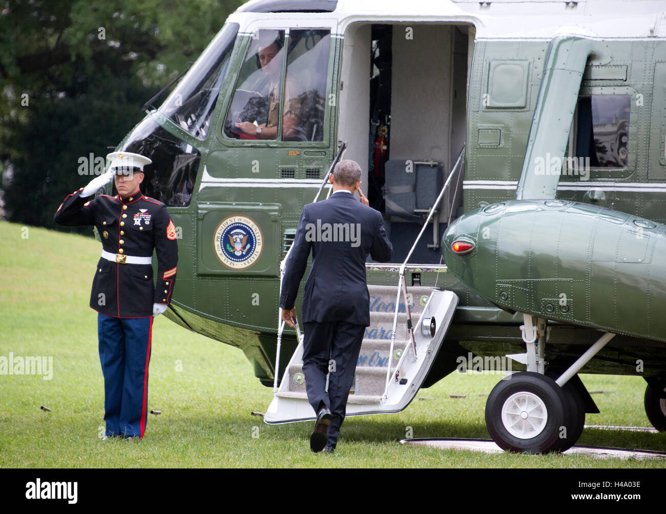 United States President Barack Obama salutes the Marine Guard as he ...
