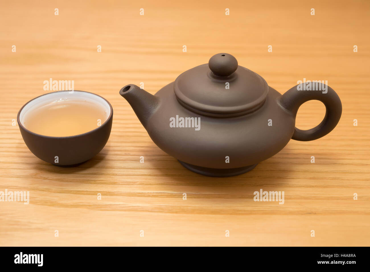 side view cup of tea and teapot on wood table Stock Photo - Alamy