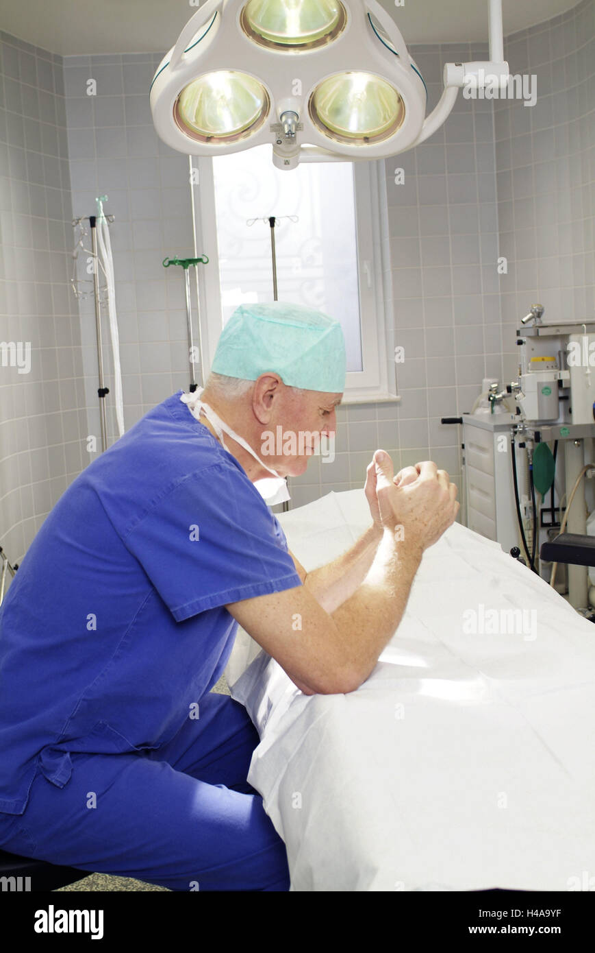 Operating room, doctor, thoughtful, sitting, side view Stock Photo - Alamy