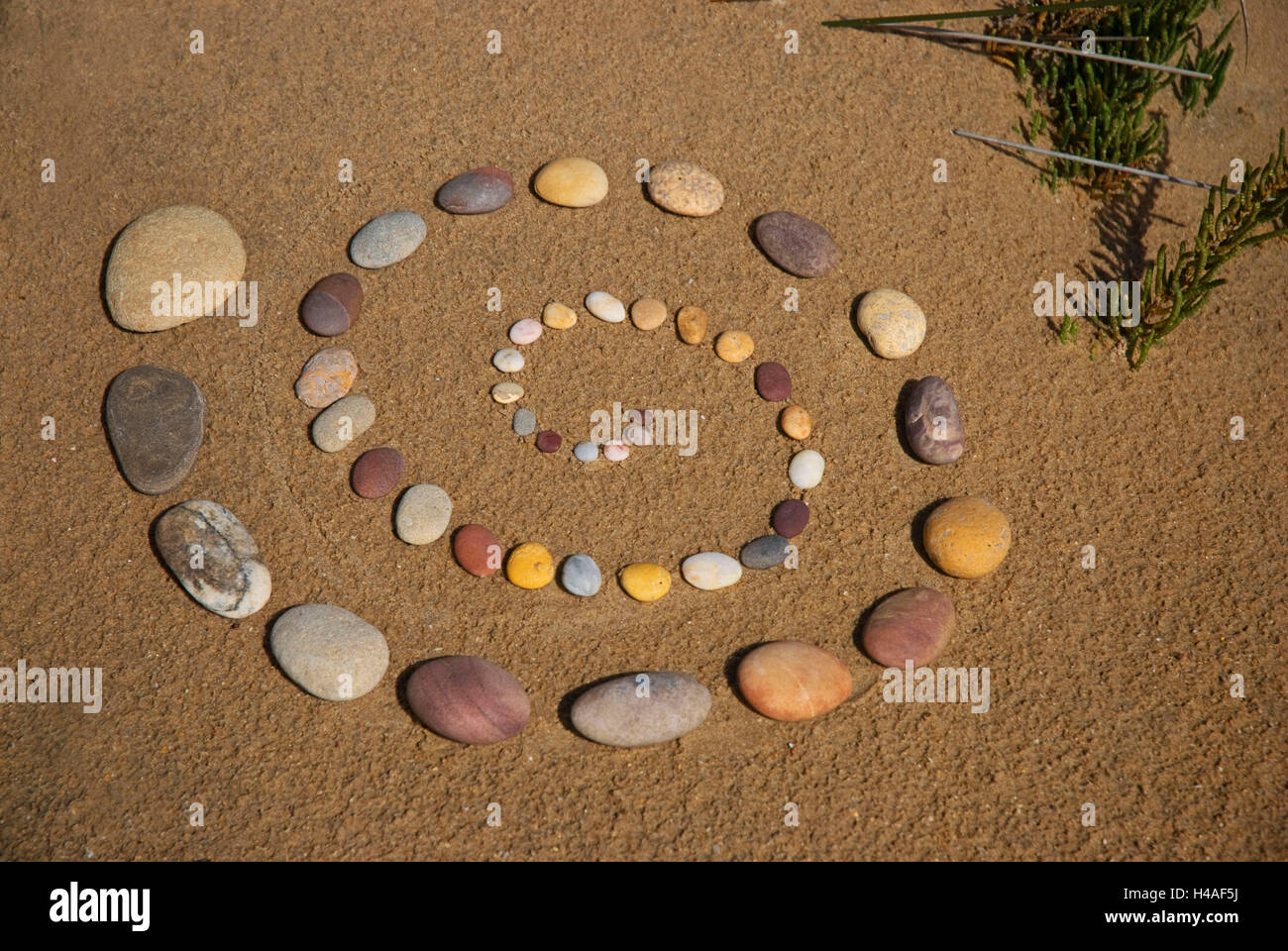 Spiral of pebble stone in the sand Stock Photo - Alamy