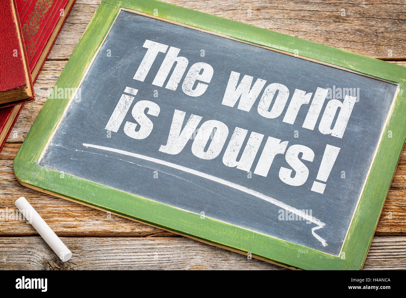 The world is yours - a positive affirmation. White chalk text on a ...