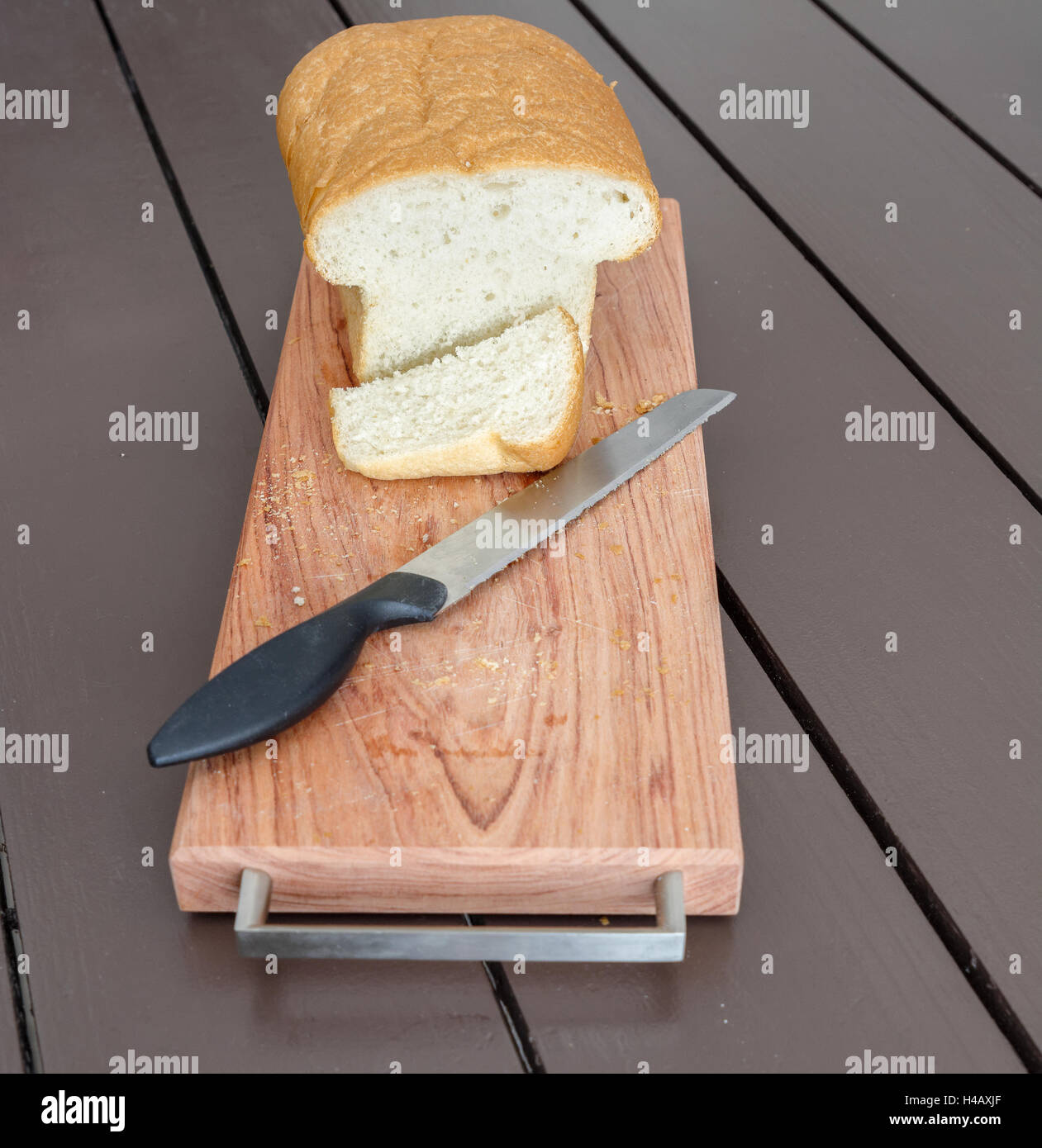 Wooden Bread Board with bread knife and slice cut from loaf of ...