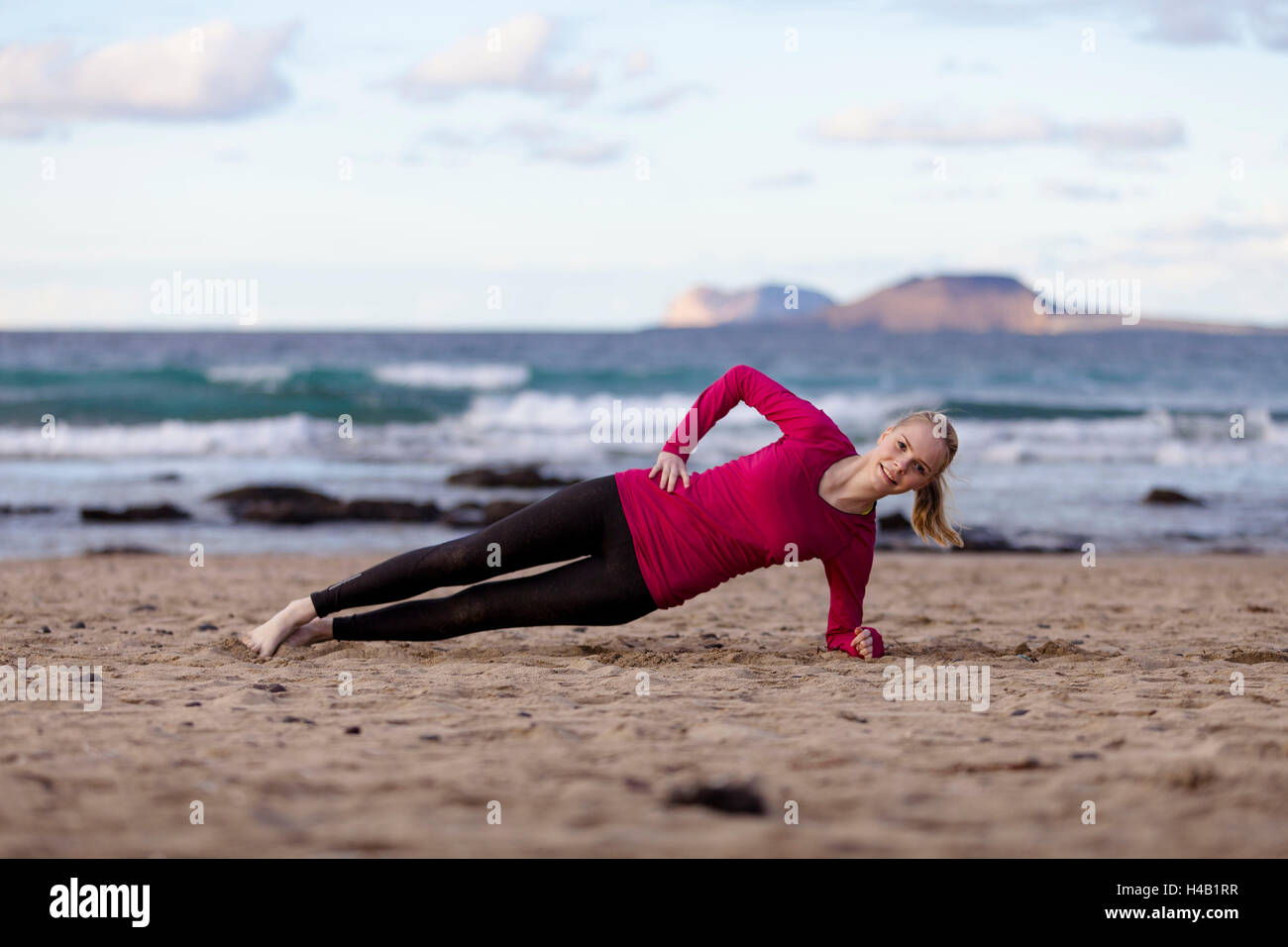 young woman doing yoga and Pilates on the beach - exercise 'board ...