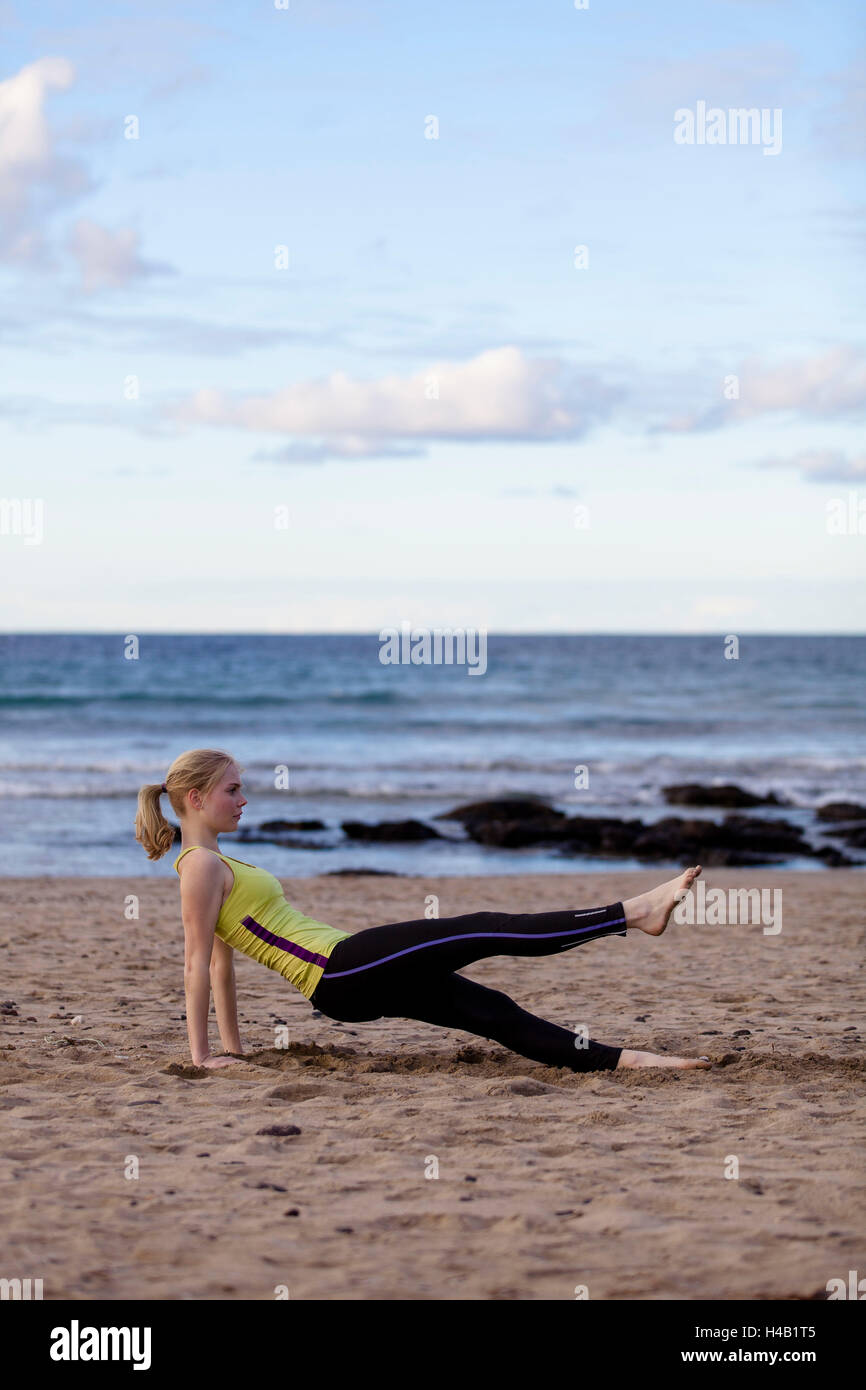 young woman doing yoga and Pilates on the beach - exercise Stock Photo ...