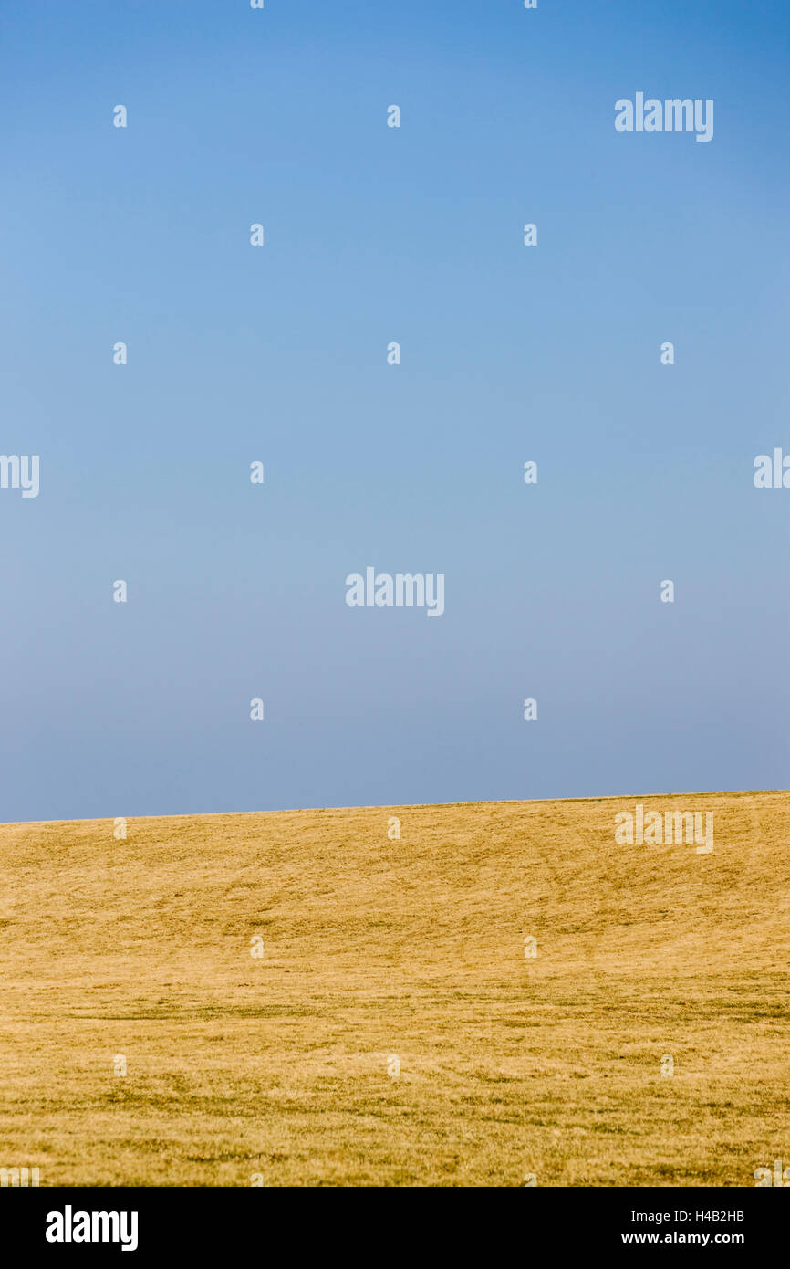 Sloping meadow in front of blue sky Stock Photo - Alamy