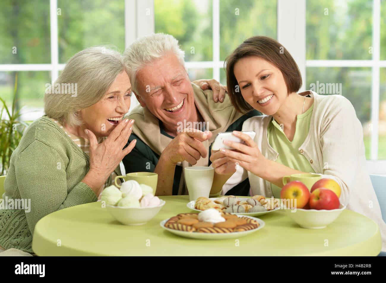 Daughter with senior parents drinking tea Stock Photo - Alamy