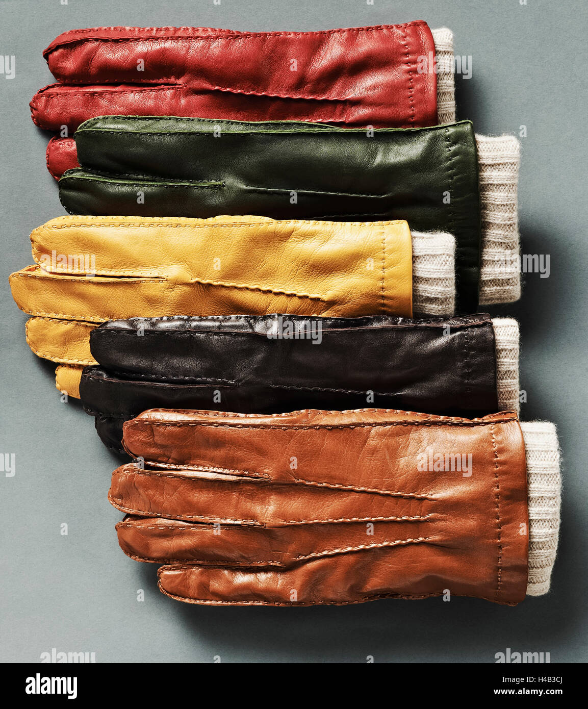 five coloured leather gloves on grey background Stock Photo - Alamy