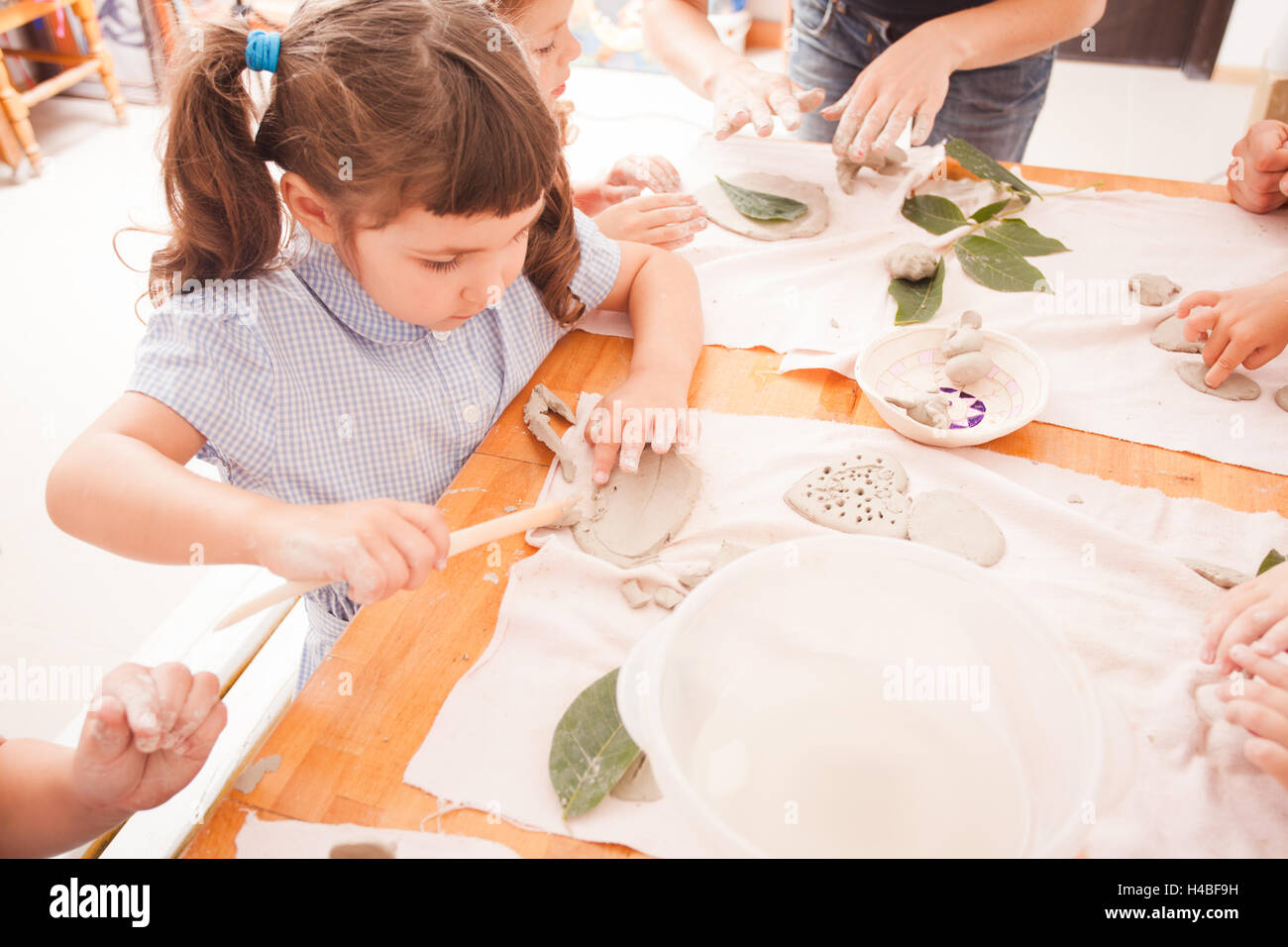 Happy children are engaged with modeling clay Stock Photo - Alamy