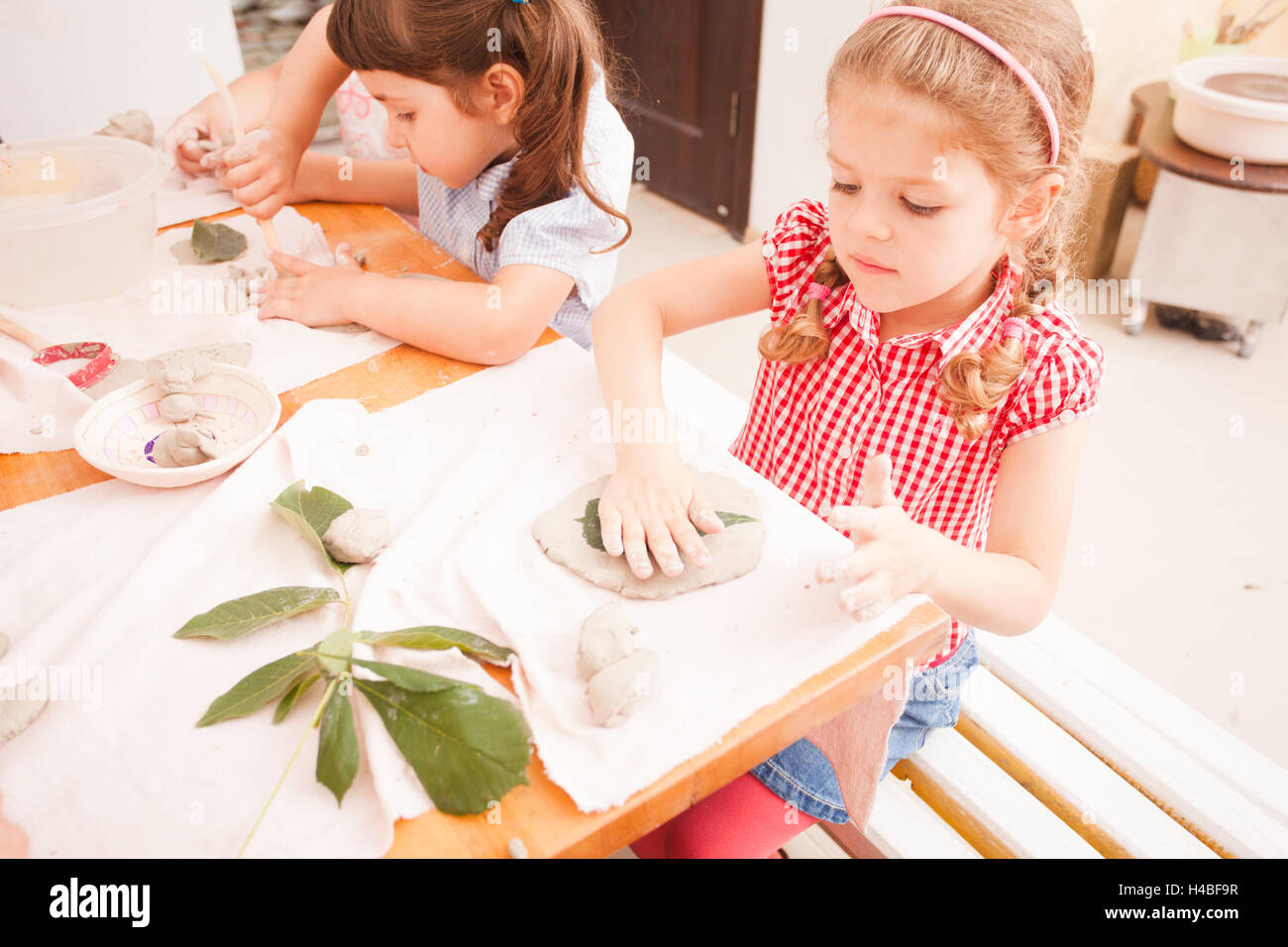 Happy children are engaged with modeling clay Stock Photo - Alamy