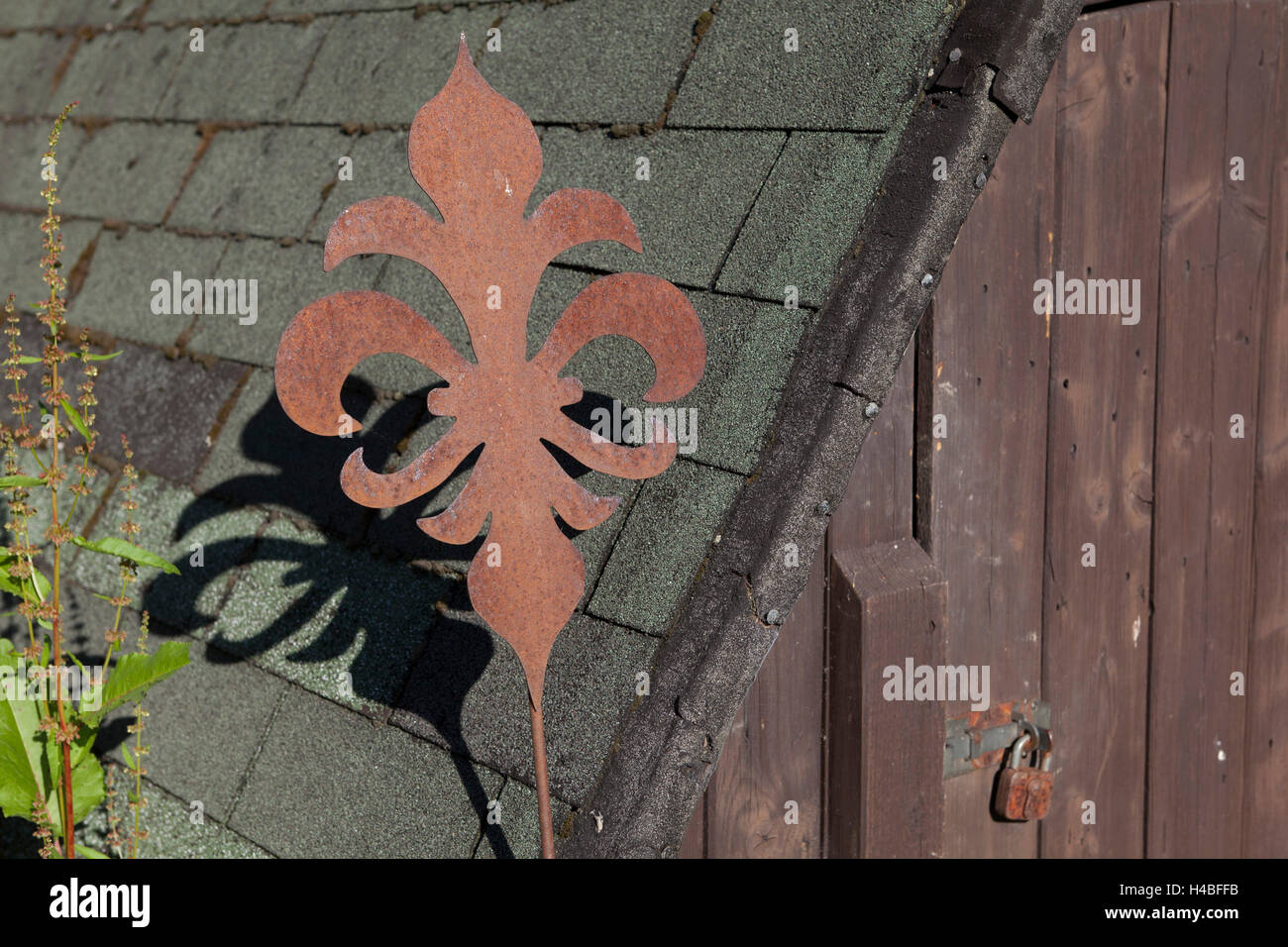 French lily made of rusty metal in front of summer house Stock Photo ...