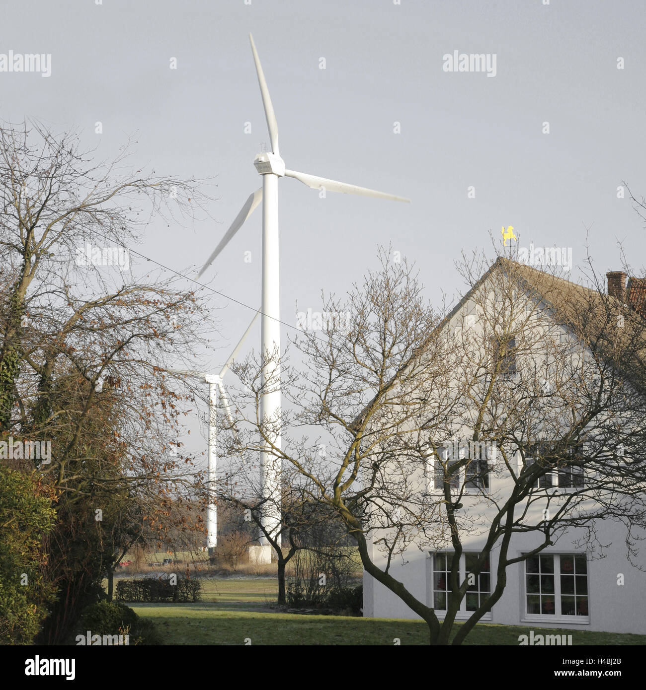 Two wind turbines beside residential house in rural environment Stock ...