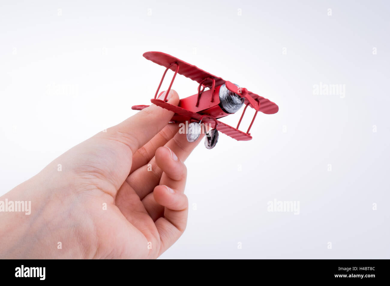 Hand holding a red Plane on a white background Stock Photo - Alamy