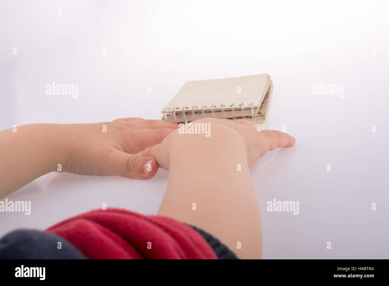 Baby holding a Spiral blank notebook on a white background Stock Photo ...