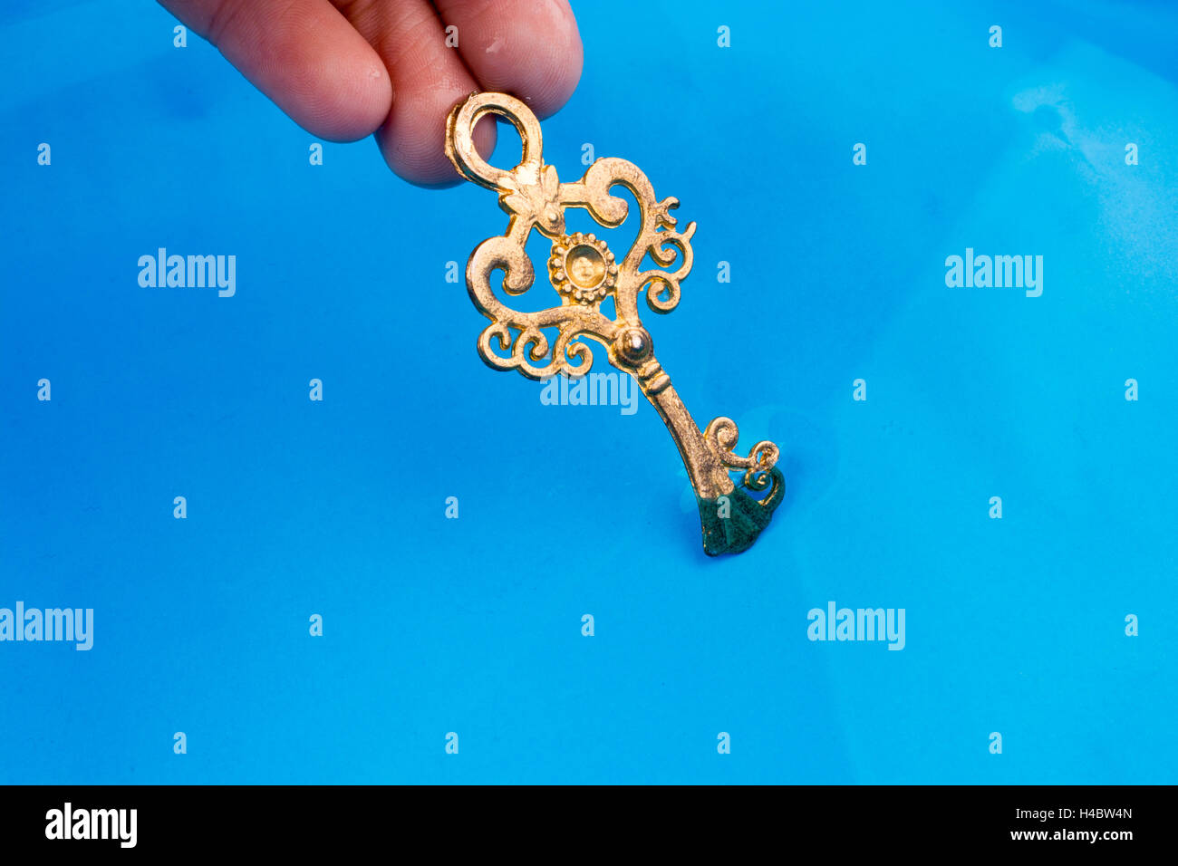 Retro styled Key in hand in water in blue background Stock Photo - Alamy