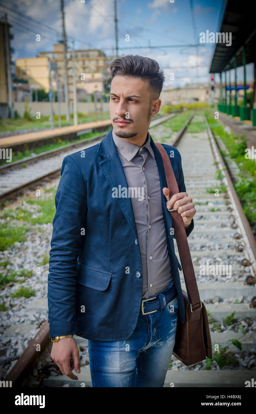 young man waiting for the train at the railway station Stock Photo - Alamy