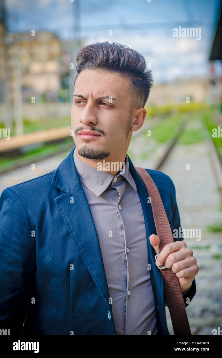 young man waiting for the train at the railway station Stock Photo - Alamy