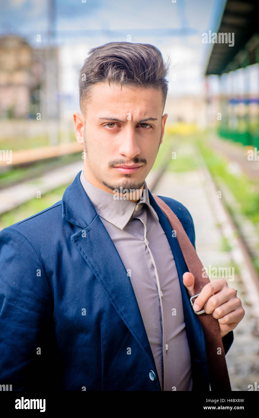 young man waiting for the train at the railway station Stock Photo - Alamy