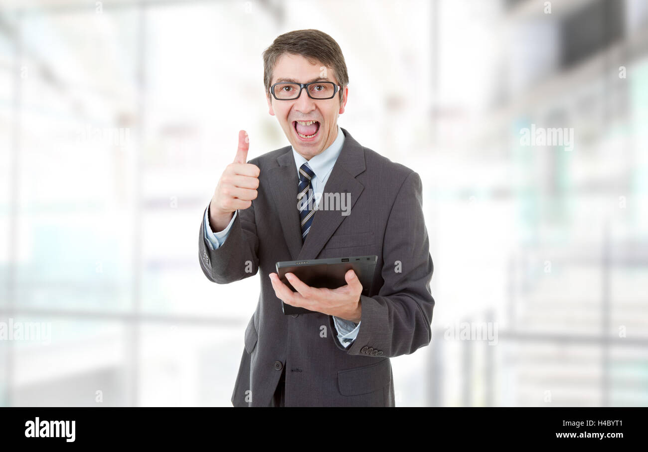 businessman using touch pad of tablet pc going thumbs up, at the office ...