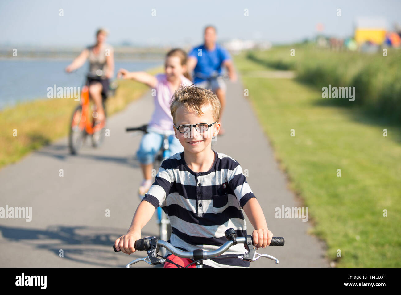 Family drives bicycle on the beach Stock Photo - Alamy